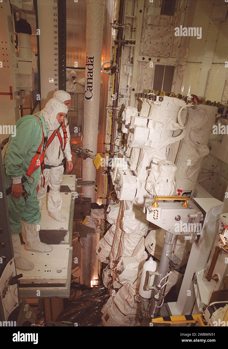 Members of the STS-100 crew look over the mission payload recently ...