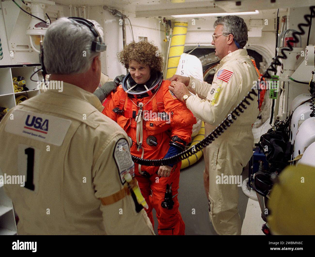 Technicians in the White Room, Launch Pad 39B, help STS-102 Mission Specialist Susan Helms with ...