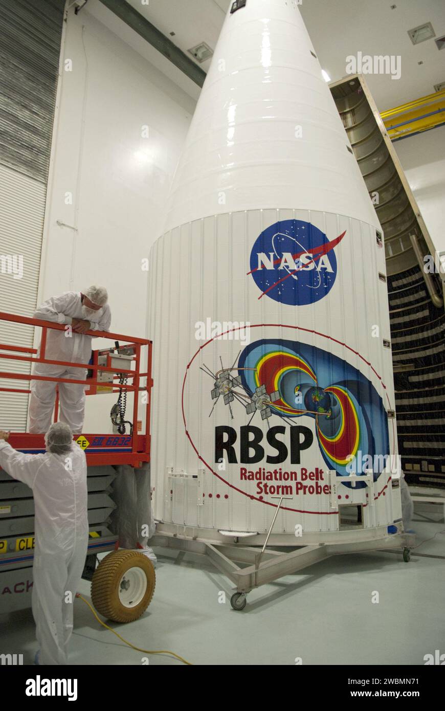 Technicians inspect the nose cone fairing of the RBSP spacecraft inside ...