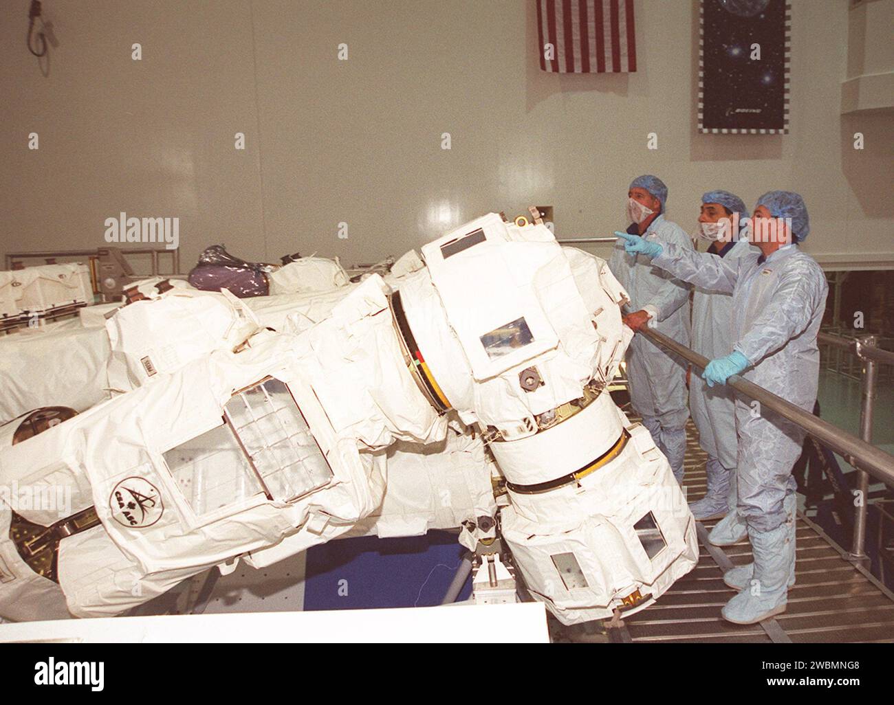 STS-100 crew members examine the Canadian robotic arm SSRMS in the ...