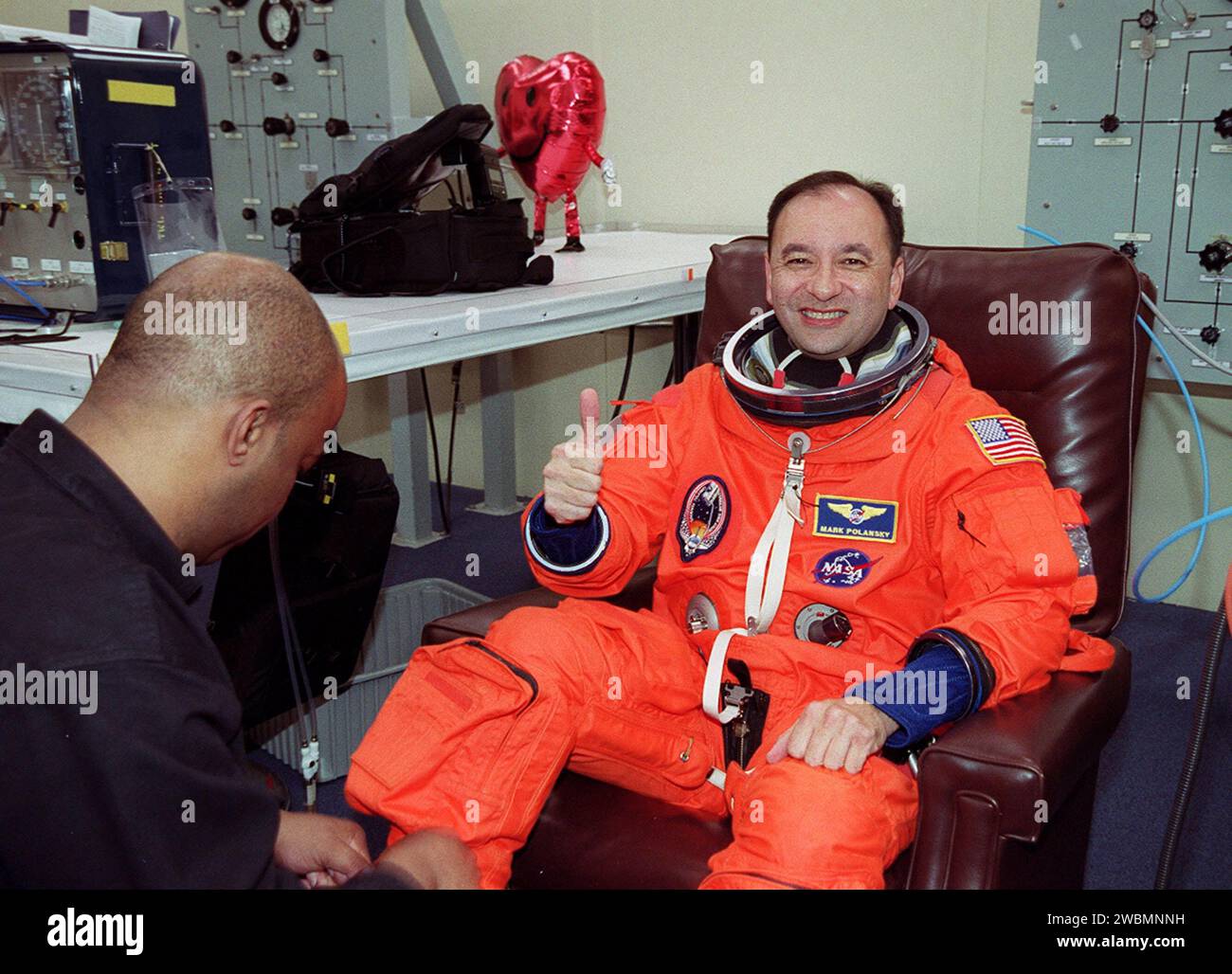 In the Operations and Checkout Building, STS-98 Pilot Mark Polansky is helped getting into his ...