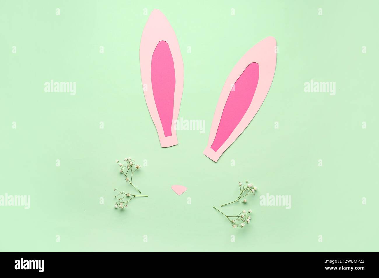 Paper bunny ears and gypsophila flowers on green background Stock Photo ...