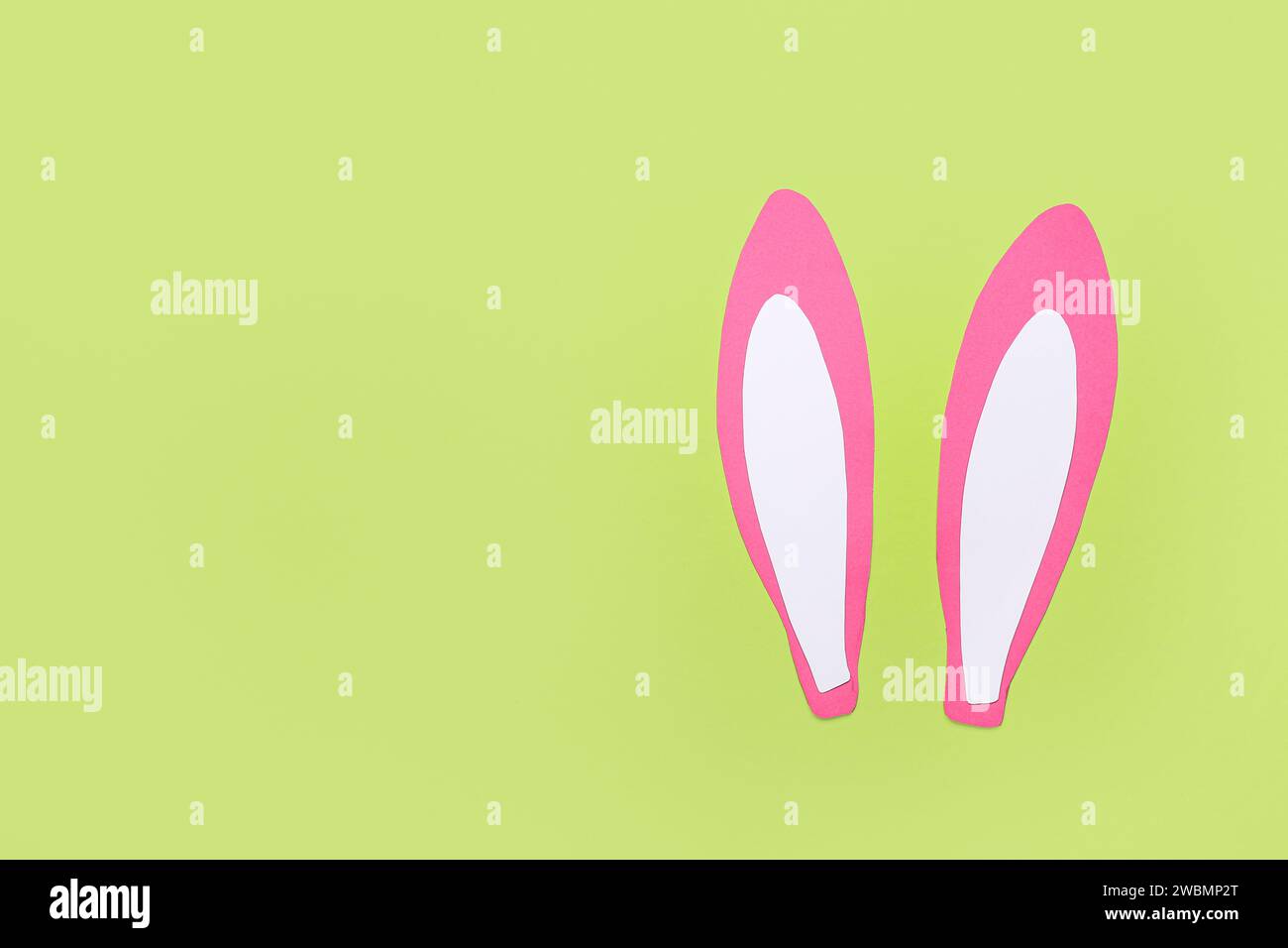Paper bunny ears on green background Stock Photo - Alamy