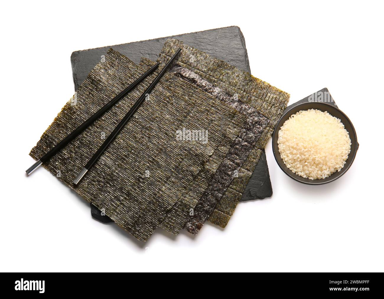 Slate board with natural nori sheets and bowl of rice isolated on white ...
