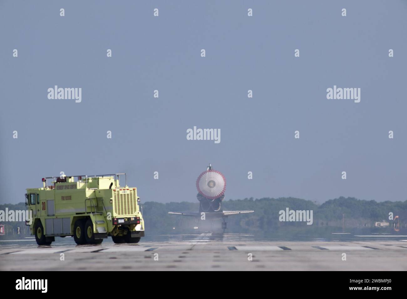 CAPE CANAVERAL, Fla. - With drag chute unfurled, space shuttle Discovery rolls past a fire ...