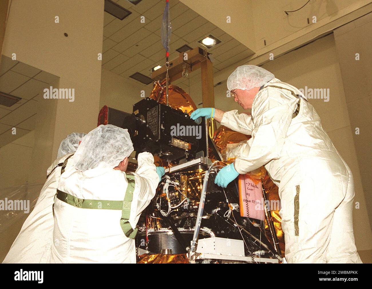 In the Spacecraft Assembly and Encapsulation Facility 2, workers help ...