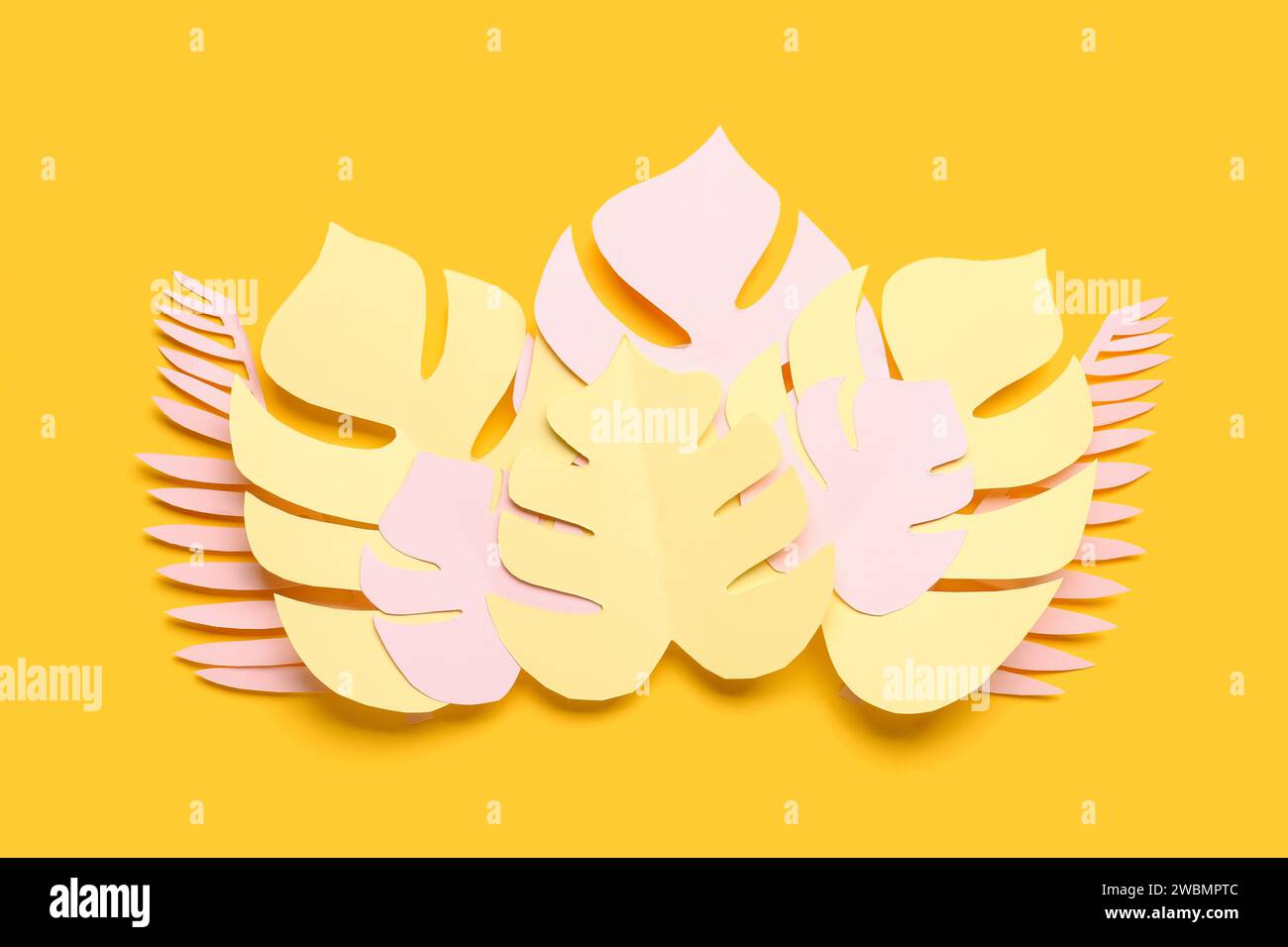 Paper tropical leaves on yellow background Stock Photo - Alamy