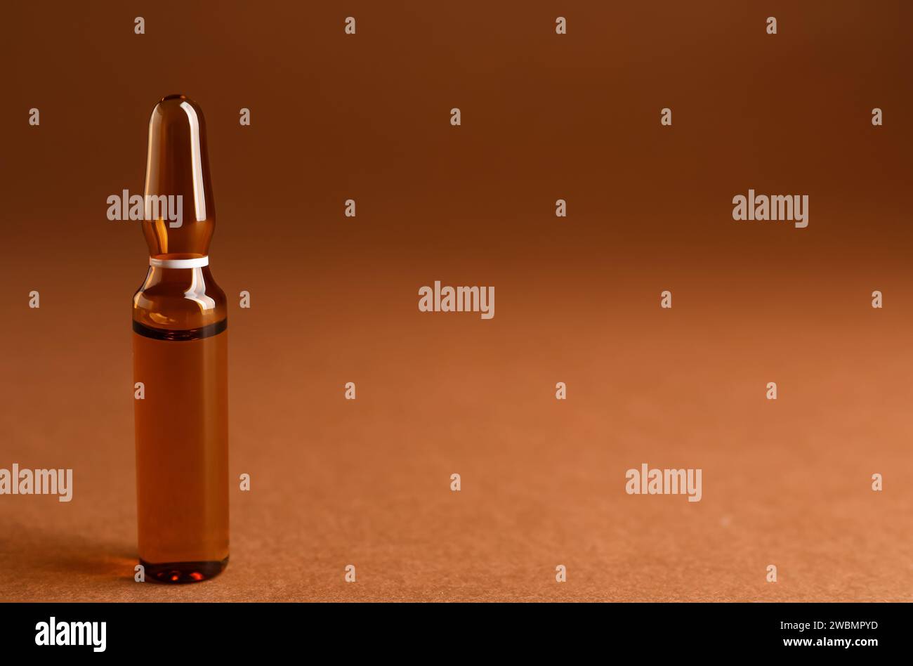 Glass ampule on brown background Stock Photo - Alamy
