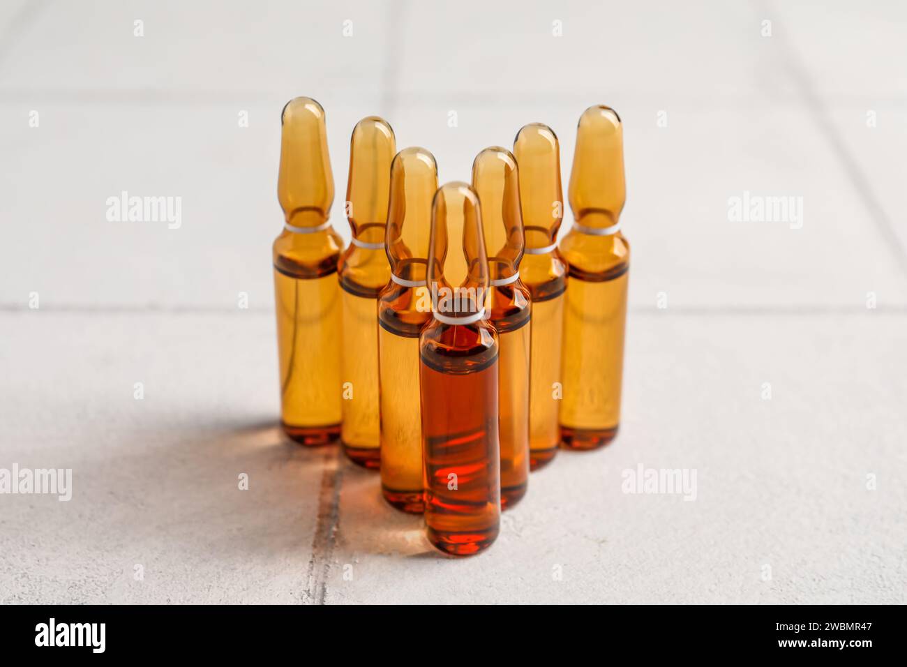 Medical ampules on white tile background Stock Photo - Alamy