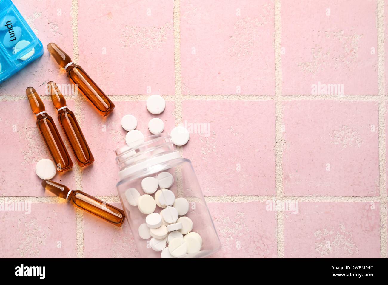 Medical ampules and pills on pink tile background Stock Photo - Alamy