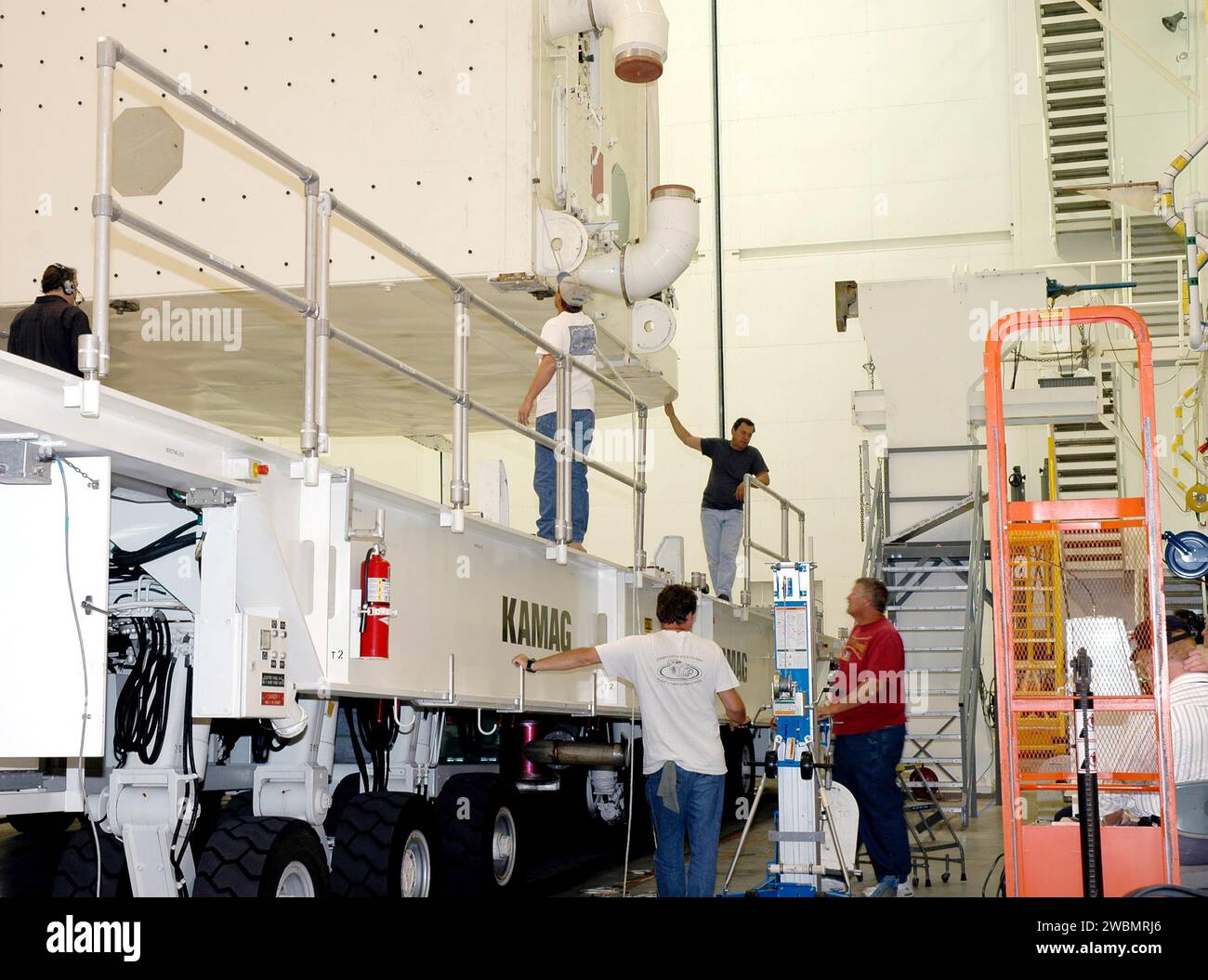 Workers at Kennedy Space Center's Canister Rotation Facility observe ...