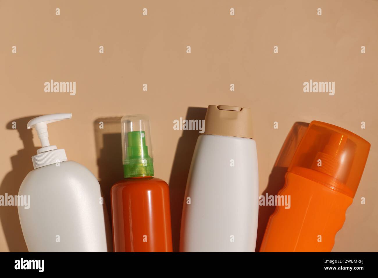Different bottles of sunscreen cream on brown background Stock Photo ...