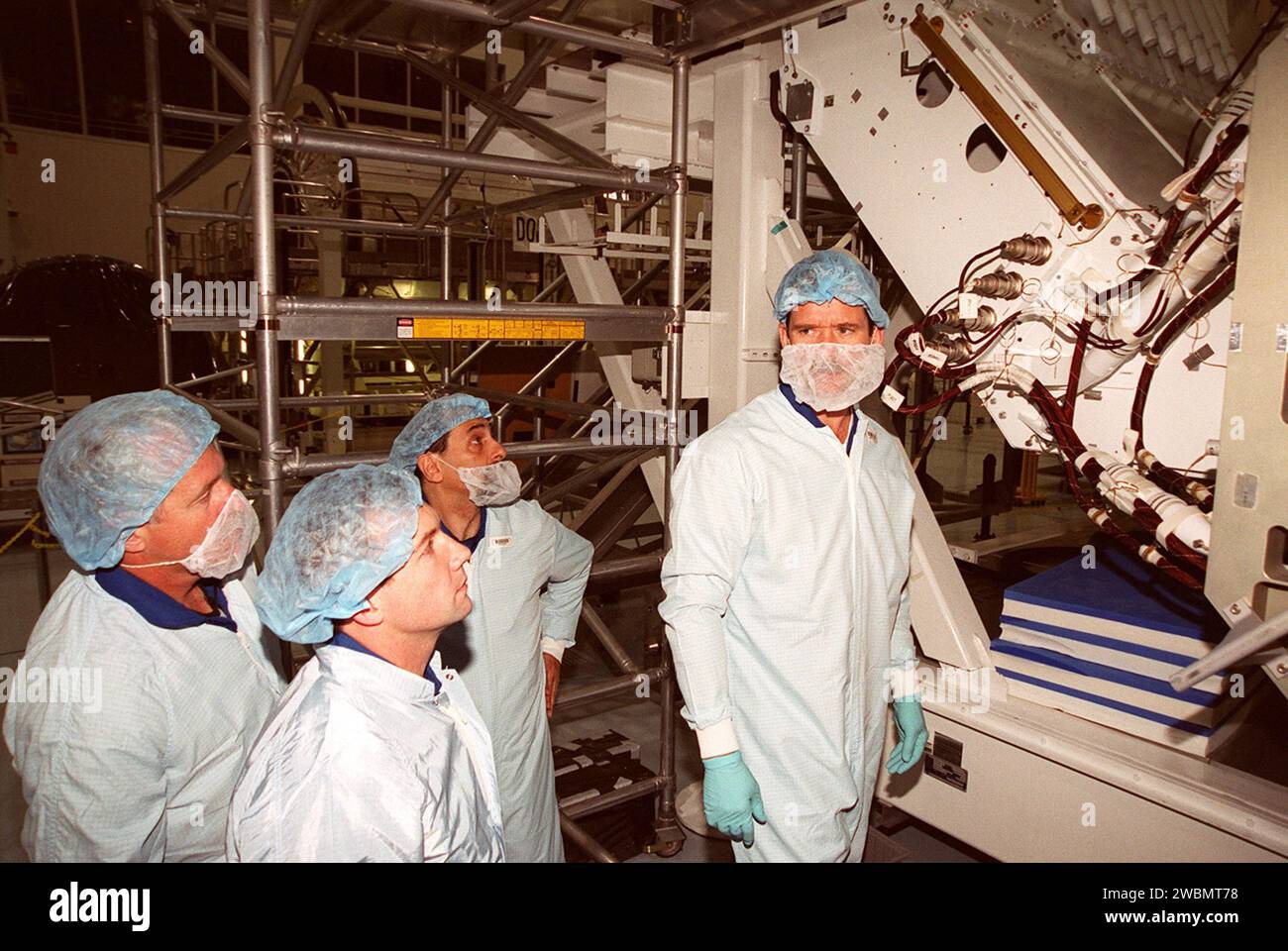 Members of the STS-100 crew, dressed in protective clothing, take a ...