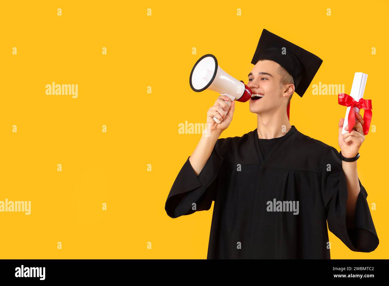 Male graduate student with diploma shouting into megaphone on yellow ...