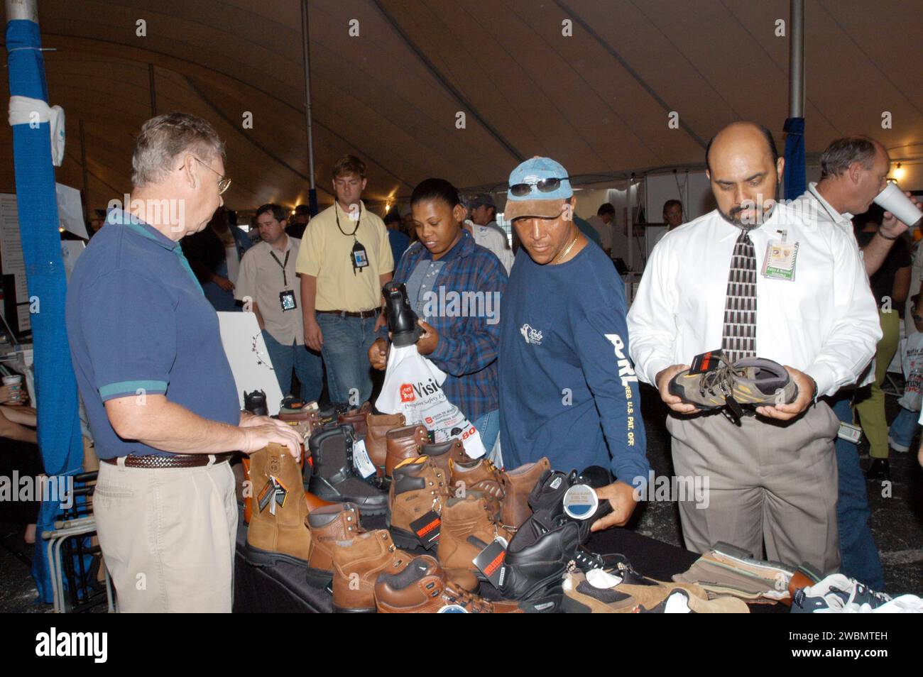 KENNEDY SPACE CENTER, FLA. - Inside a tent, employees look over an ...