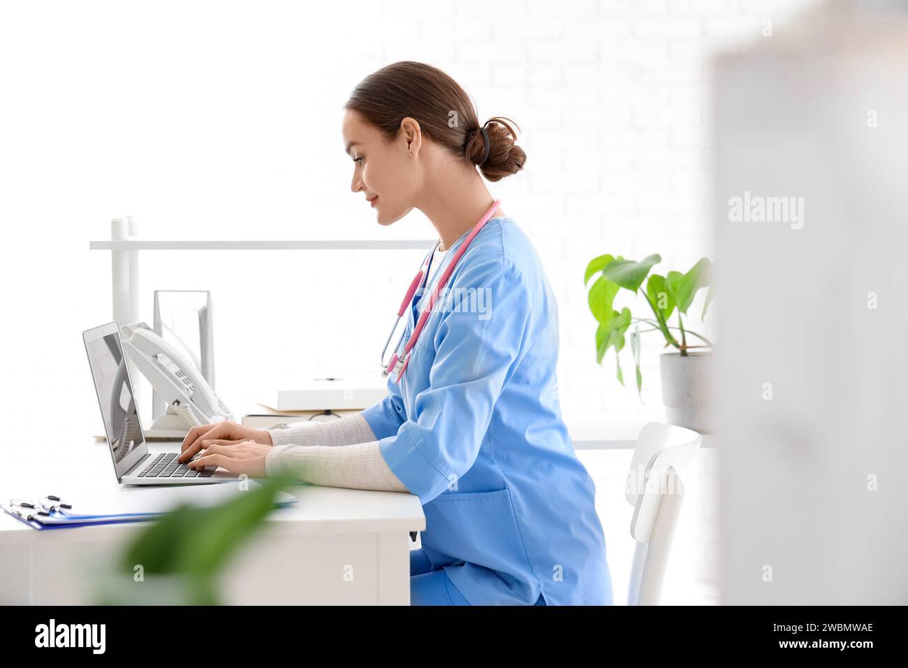 Female medical intern working with laptop in clinic Stock Photo - Alamy