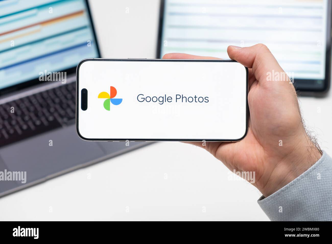 Google Photos logo of app on the screen of mobile phone held by man in ...