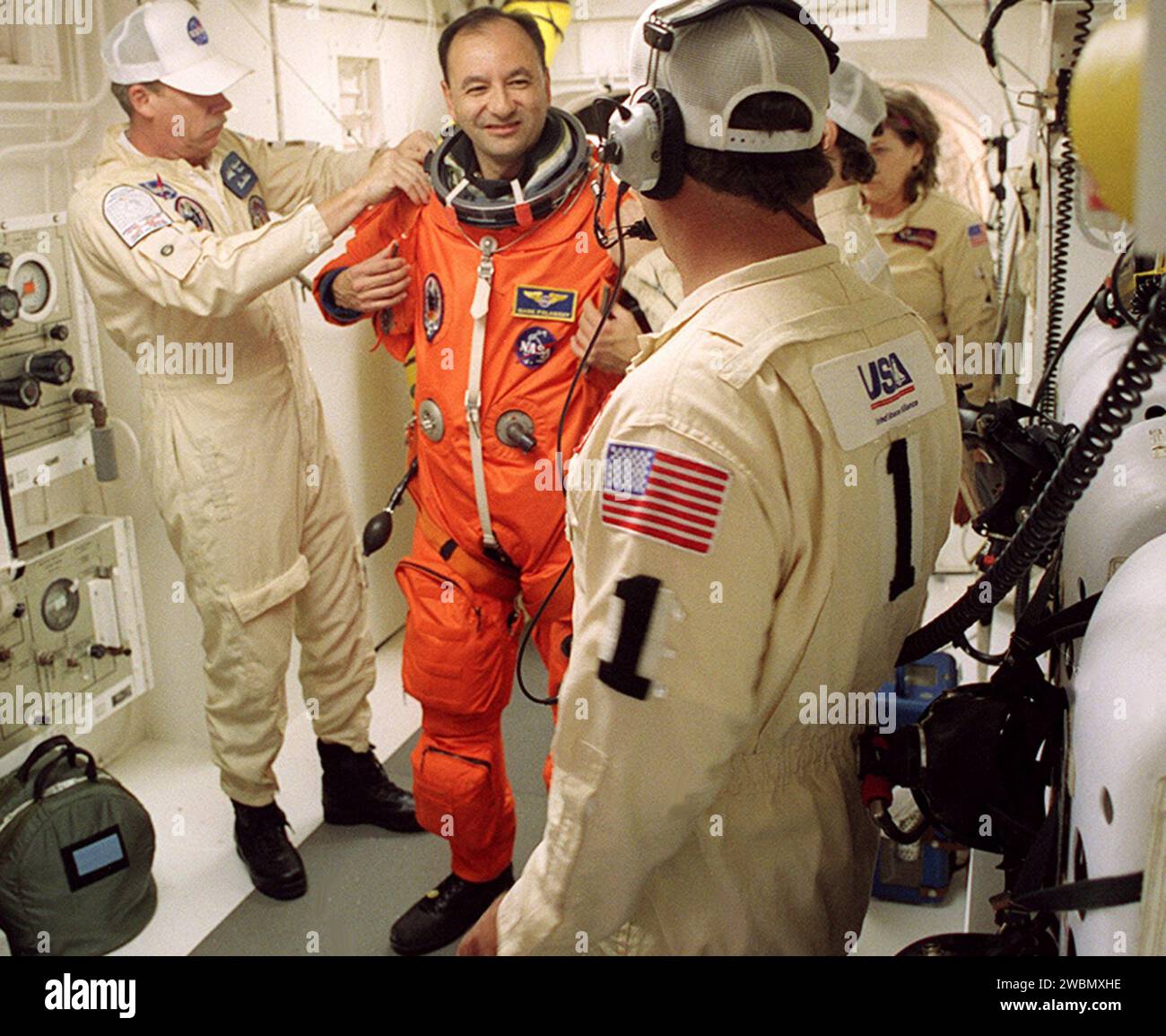 In the White Room with the closeout crew, STS-98 Pilot Mark Polansky happily undergoes final ...