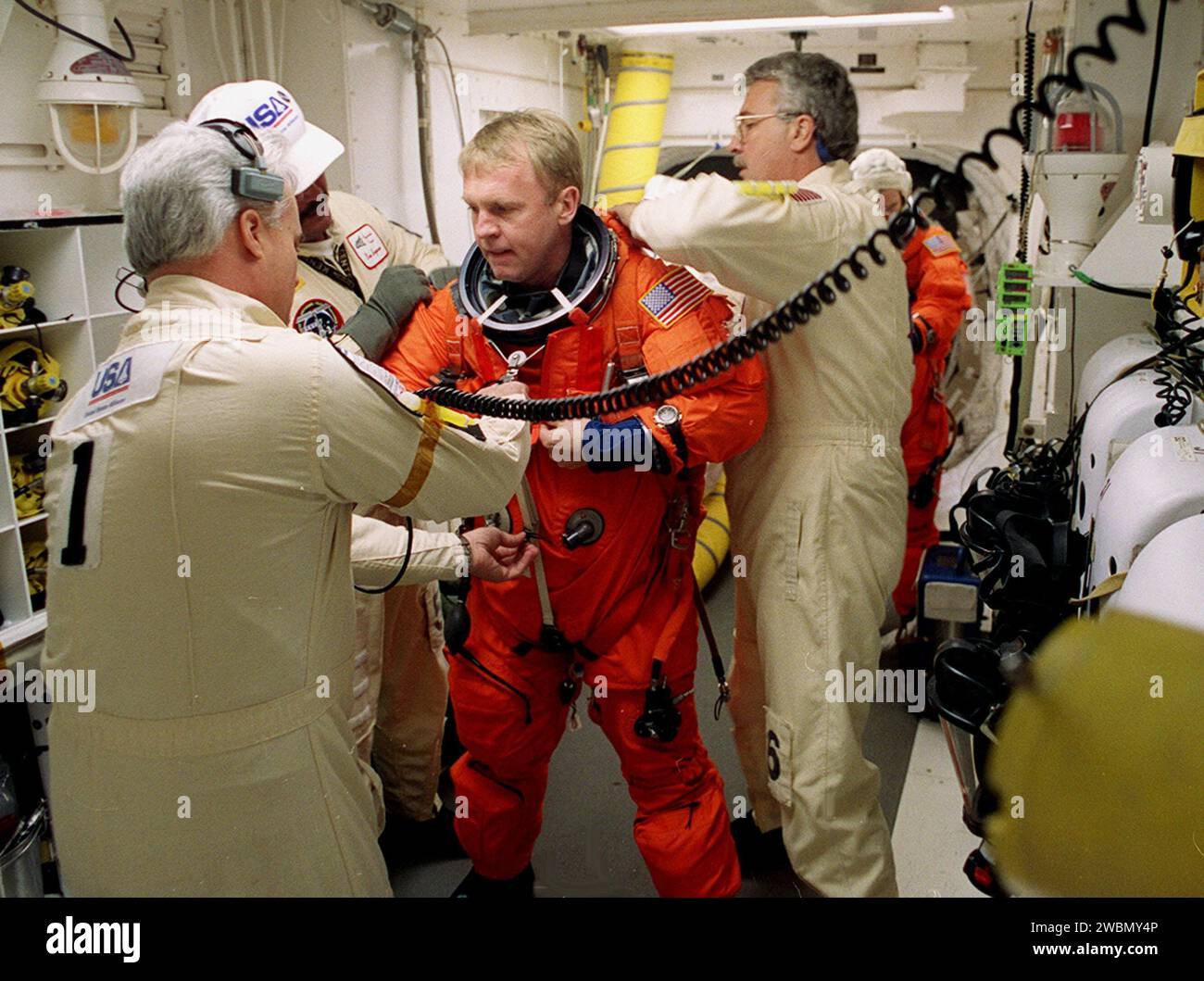 Before entering Space Shuttle Discovery, STS-102 Mission Specialist Andrew Thomas is helped with ...