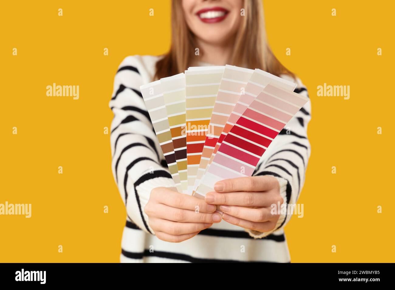 Young woman with color palettes on yellow background Stock Photo - Alamy