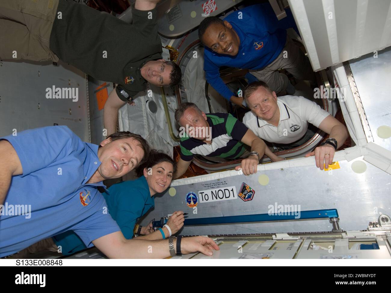 In the newly-installed Permanent Multipurpose Module (PMM), the STS-133 crew members pose while ...