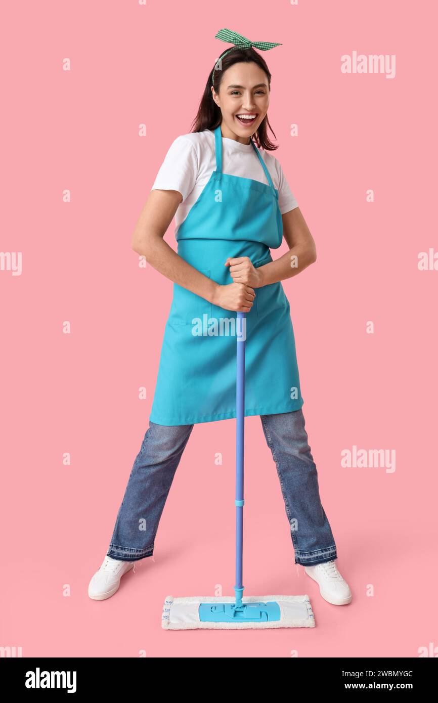 Pretty young woman with mop on pink background Stock Photo - Alamy