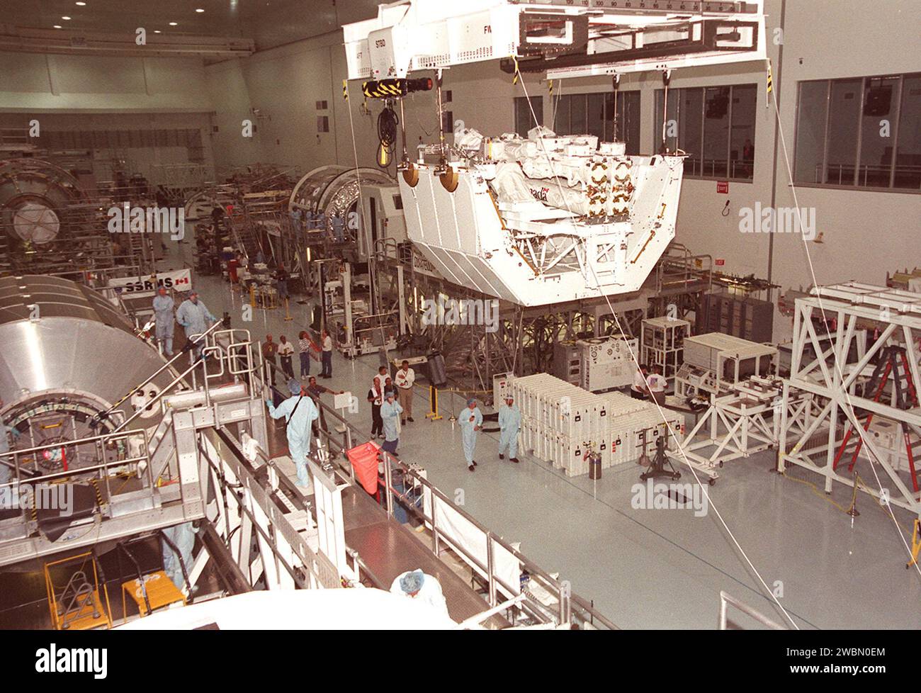 Workers on the floor of the Space Station Processing Facility follow ...