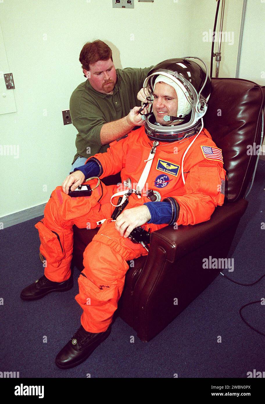 STS-102 Mission Specialist Paul Richards has his launch suit checked for fit in the Operations ...
