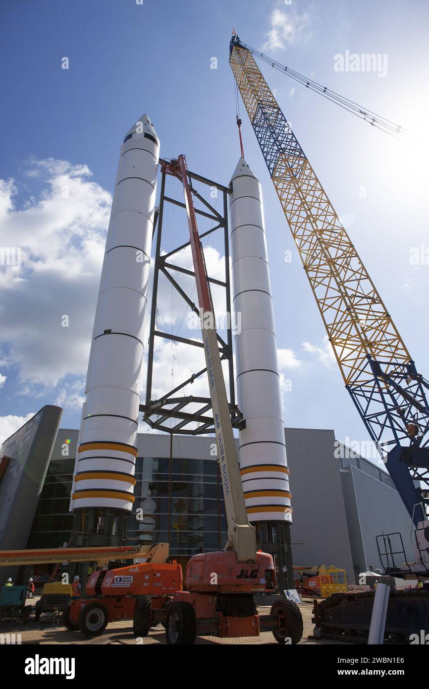 A crane lifts the nosecone part of a solid rocket booster replica into ...
