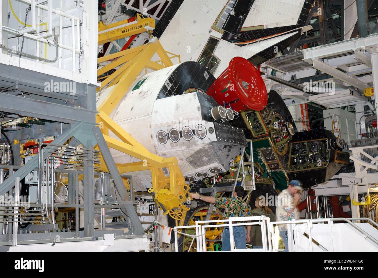 Technicians at Kennedy Space Center inspect the left OMS pod on ...