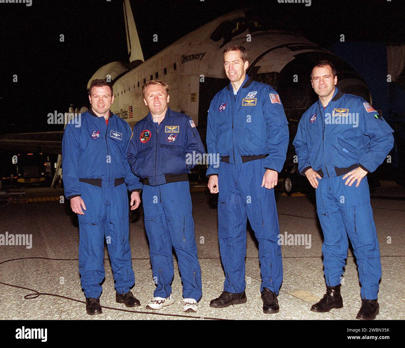 After exiting the Crew Transport Vehicle, the STS-102 crew gathers under Discovery for a walk ...