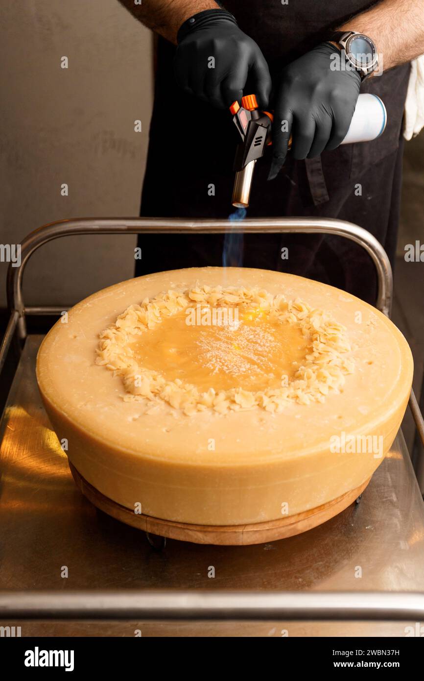 The chef melts the cheese using the heat of a hand-held gas torch ...