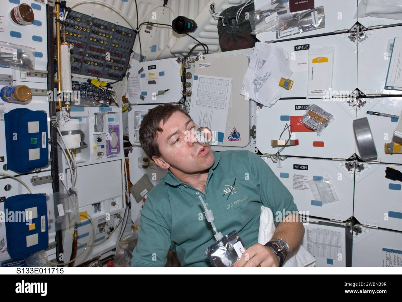 NASA astronaut Michael Barratt, STS-133 mission specialist, observes a ...