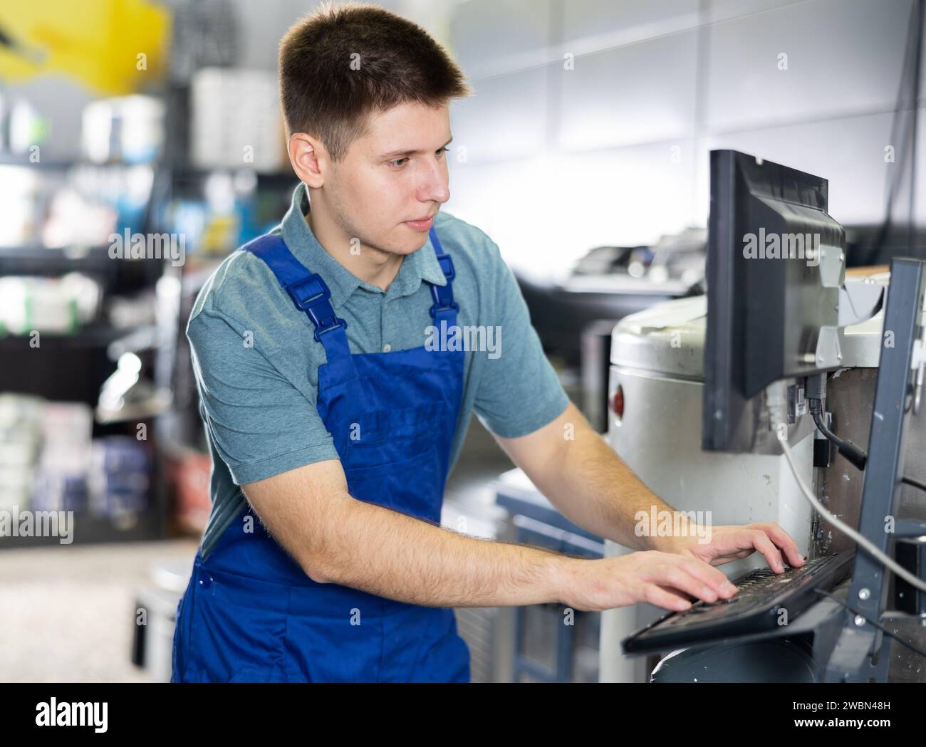 Warehouse guy employee look at computer monitor screen and check ...