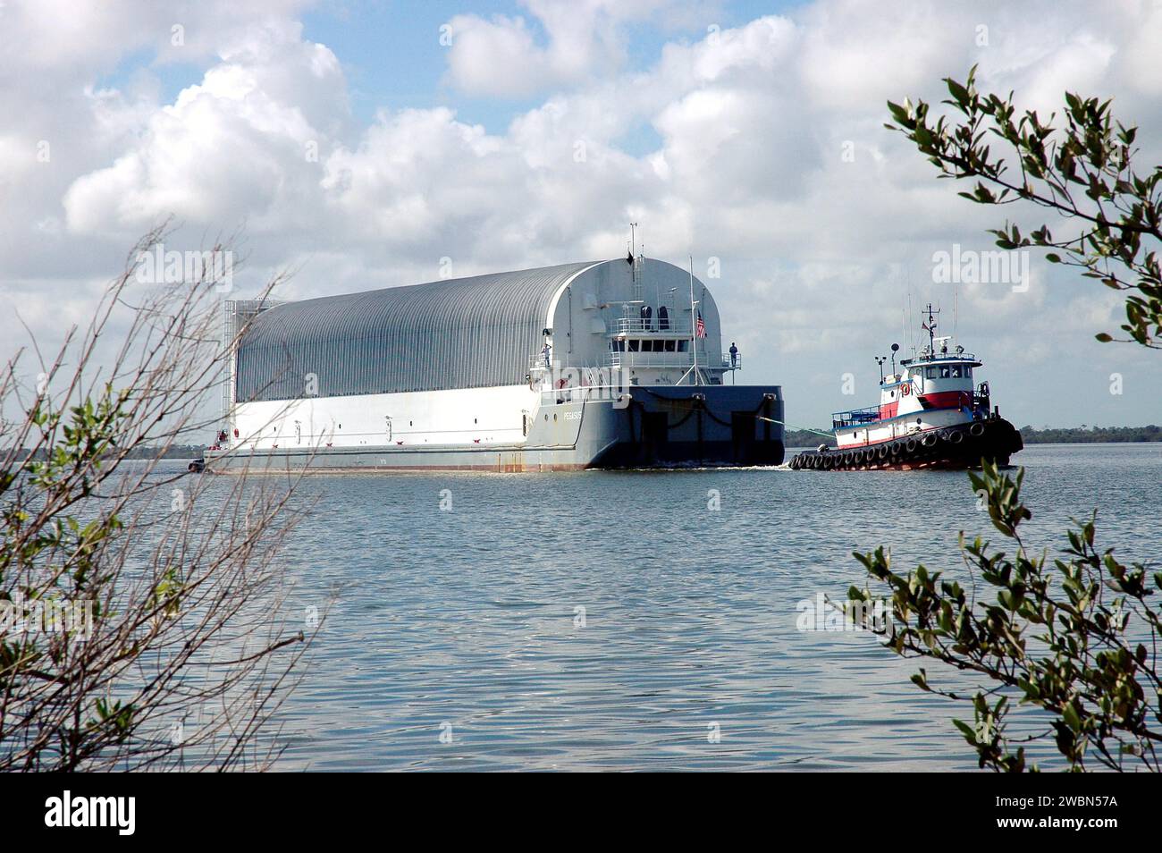 KENNEDY SPACE CENTER, FLA. - A tugboat tows the barge carrying the ...