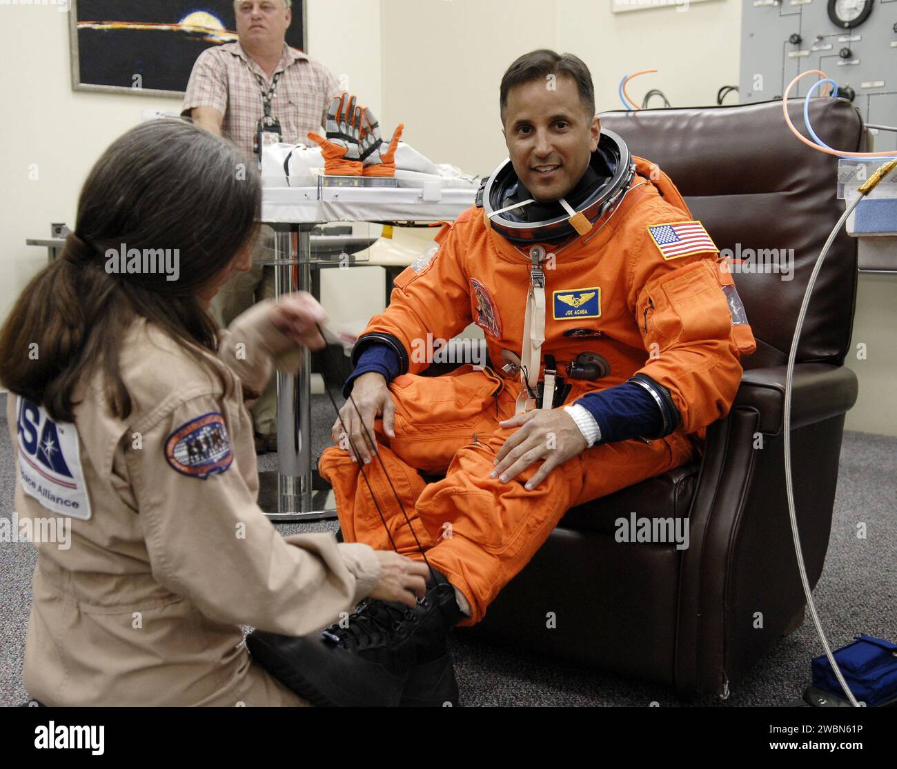 Mission Specialist Joseph Acaba is assisted with his launch-and-entry ...