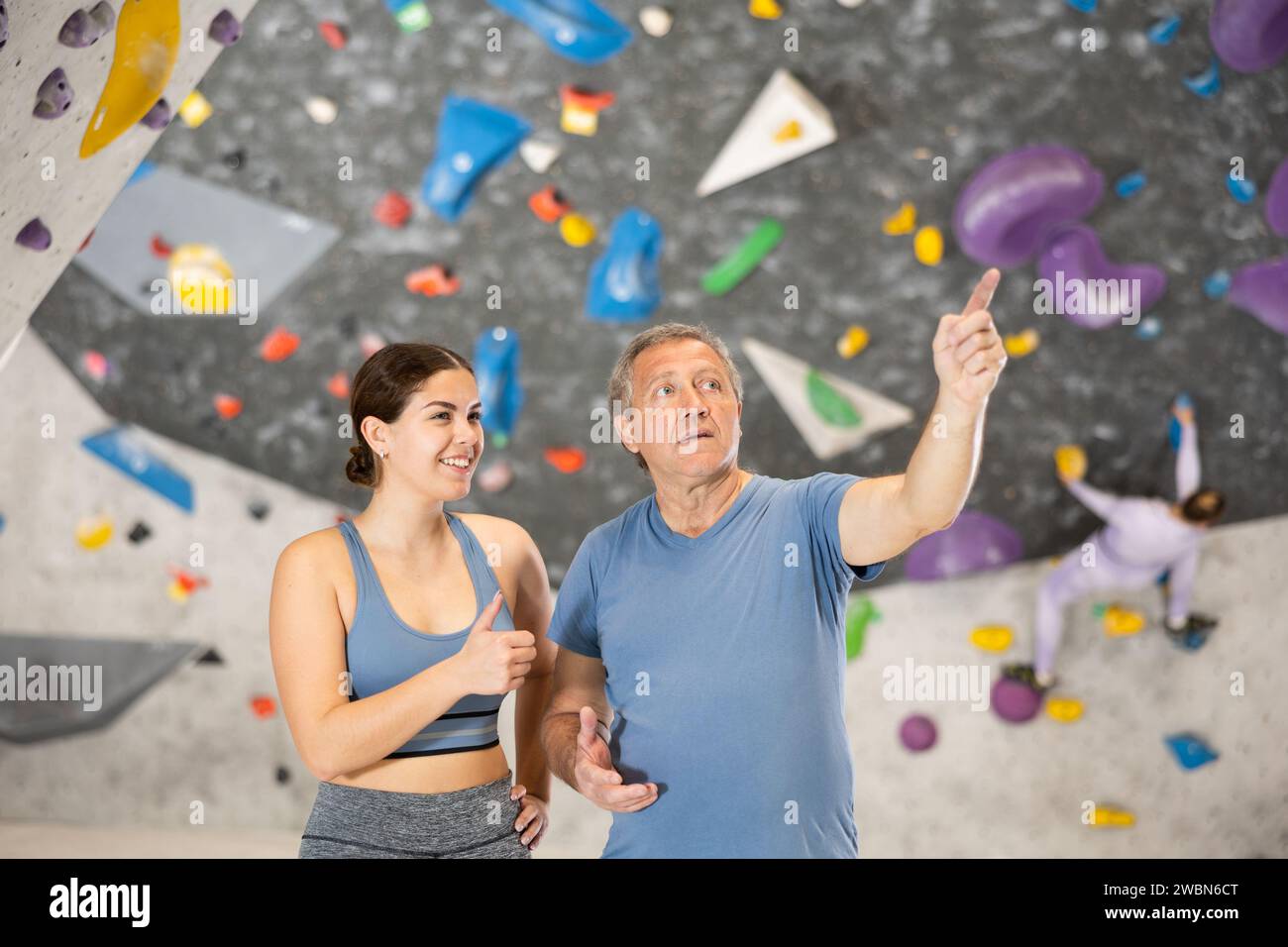 Adult man and young woman posing on climbing wall Stock Photo - Alamy