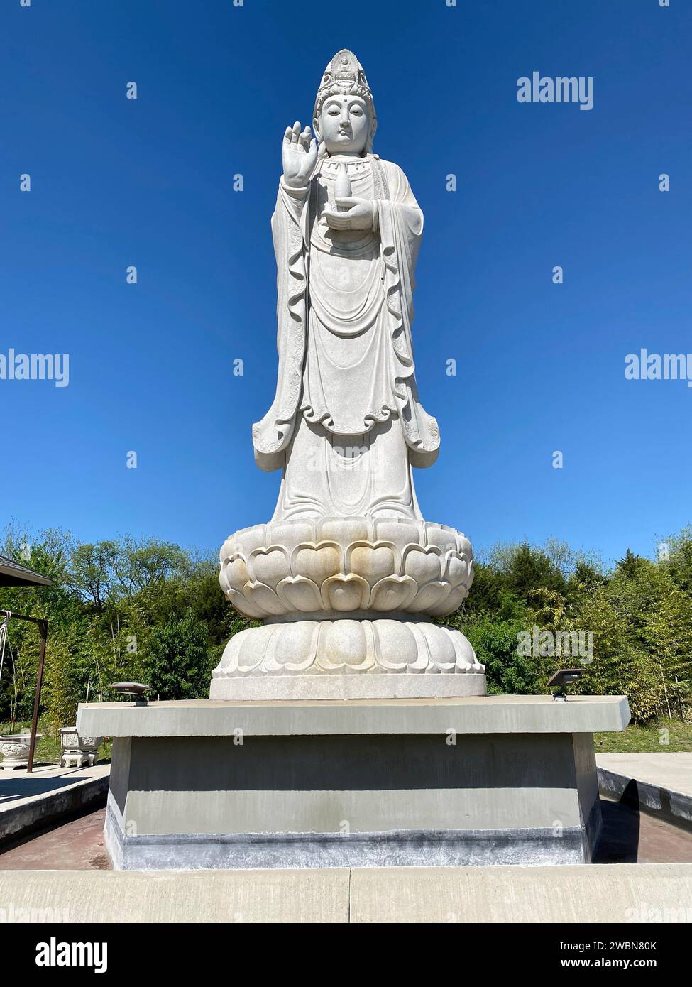A pristine white statue stands gracefully amidst a lush green landscape ...