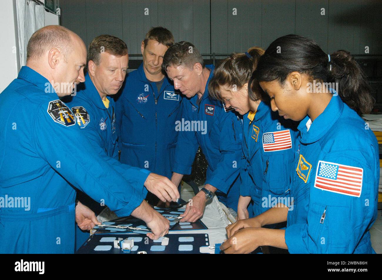 STS-121 crew members at Kennedy Space Center examine panel assemblies ...