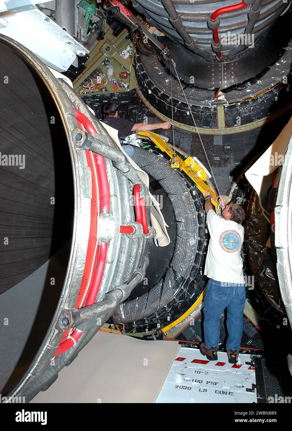 At Kennedy Space Center, technicians attach dome heat shields to ...