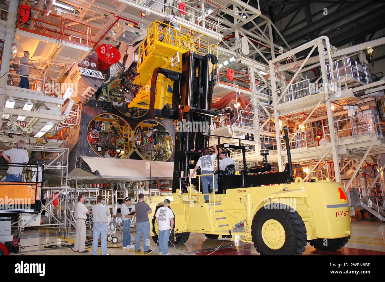 KENNEDY SPACE CENTER, FLA. - In the Orbiter Processing Facility, technicians wait below while a ...