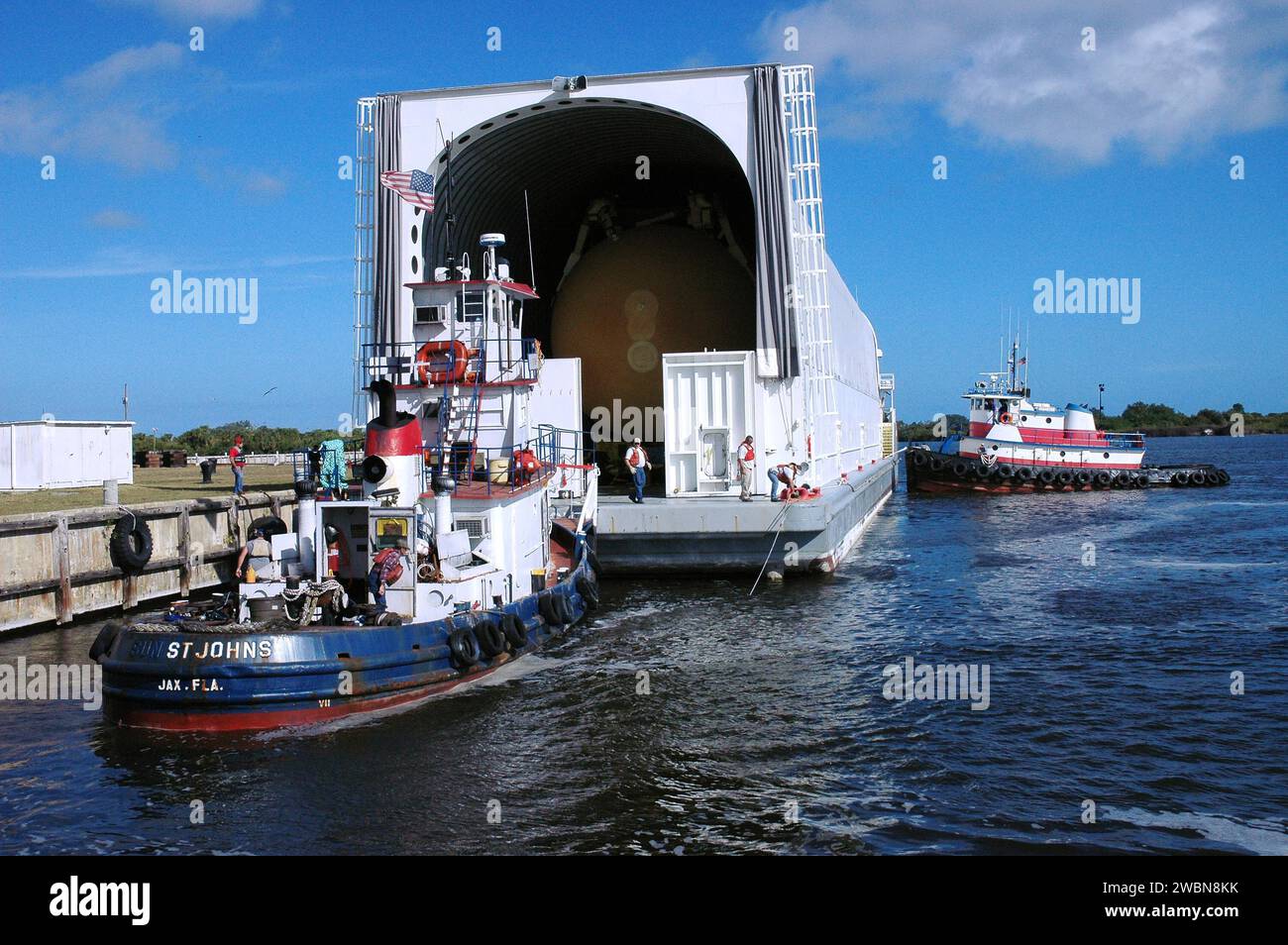 KENNEDY SPACE CENTER, FLA. - Tugboats maneuver the barge carrying the ...