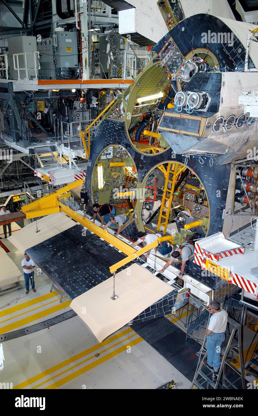 Workers at Kennedy Space Center install Atlantis’ body flap behind the ...