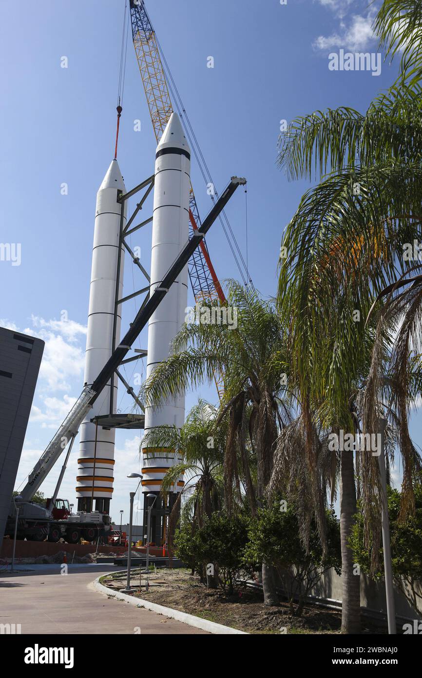 A crane lifts the nosecone part of a solid rocket booster replica into ...