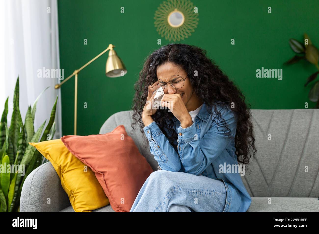 Lonely sad woman crying sitting at home on sofa in living room of house ...