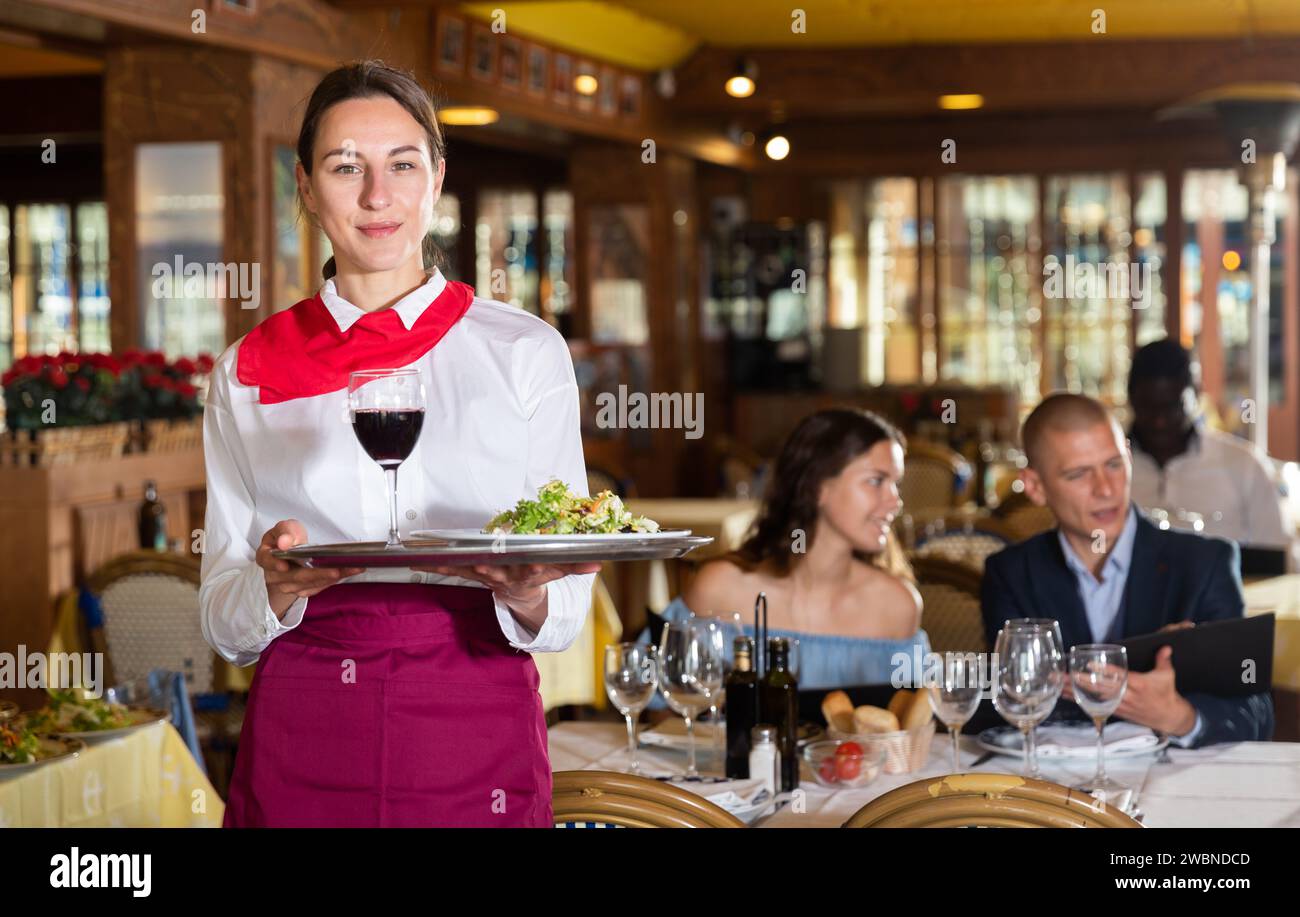 Waiter standing with serving tray, recommending dishes in restaurant ...