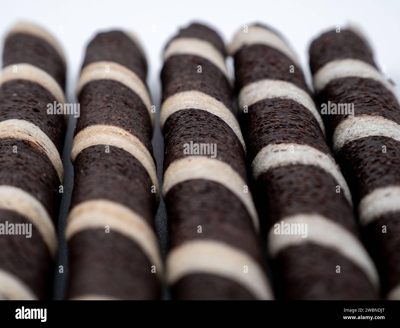Crispy waffle rolls on a white background. Black and white wafer rolls ...