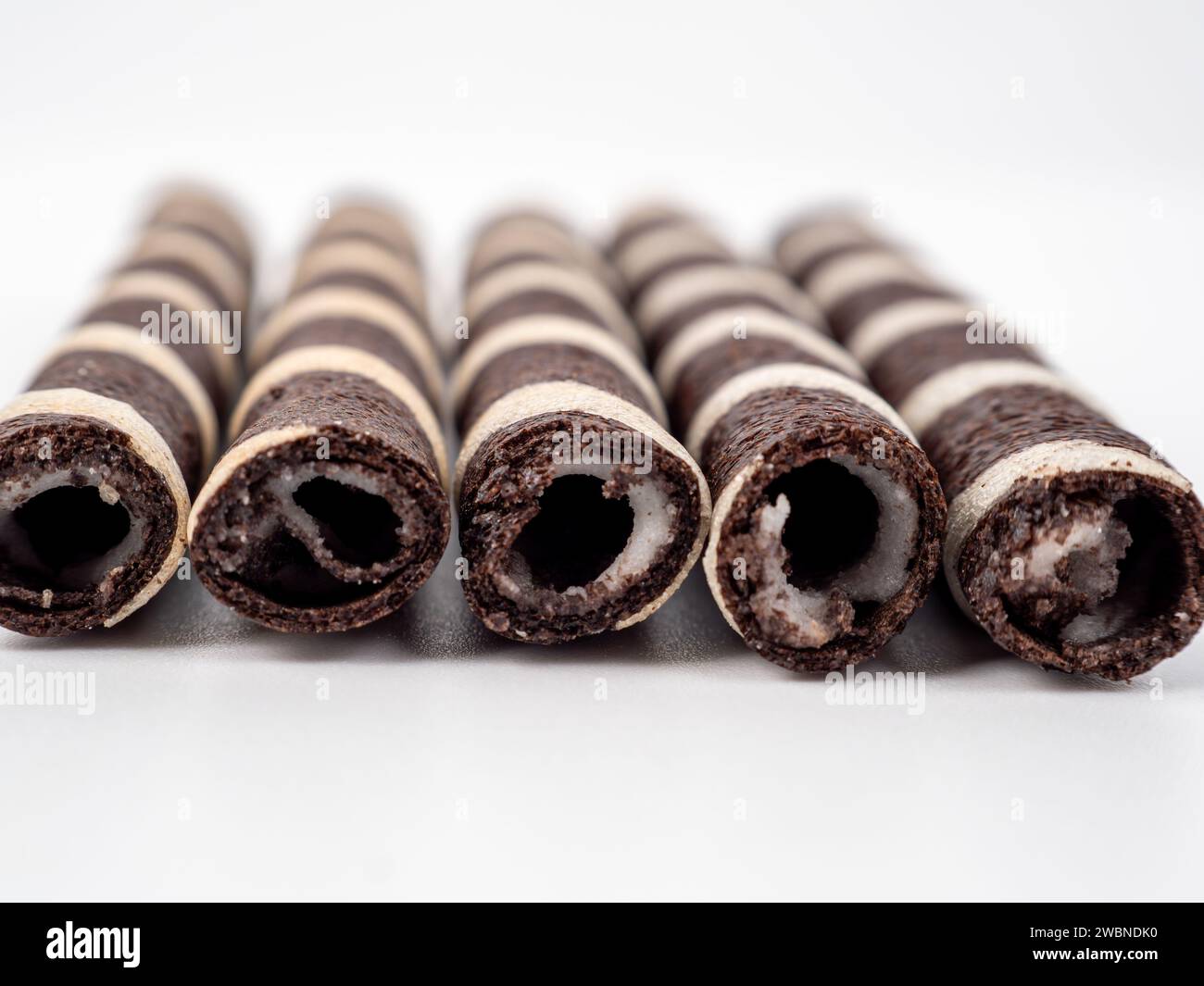 Crispy waffle rolls on a white background. Black and white wafer rolls ...