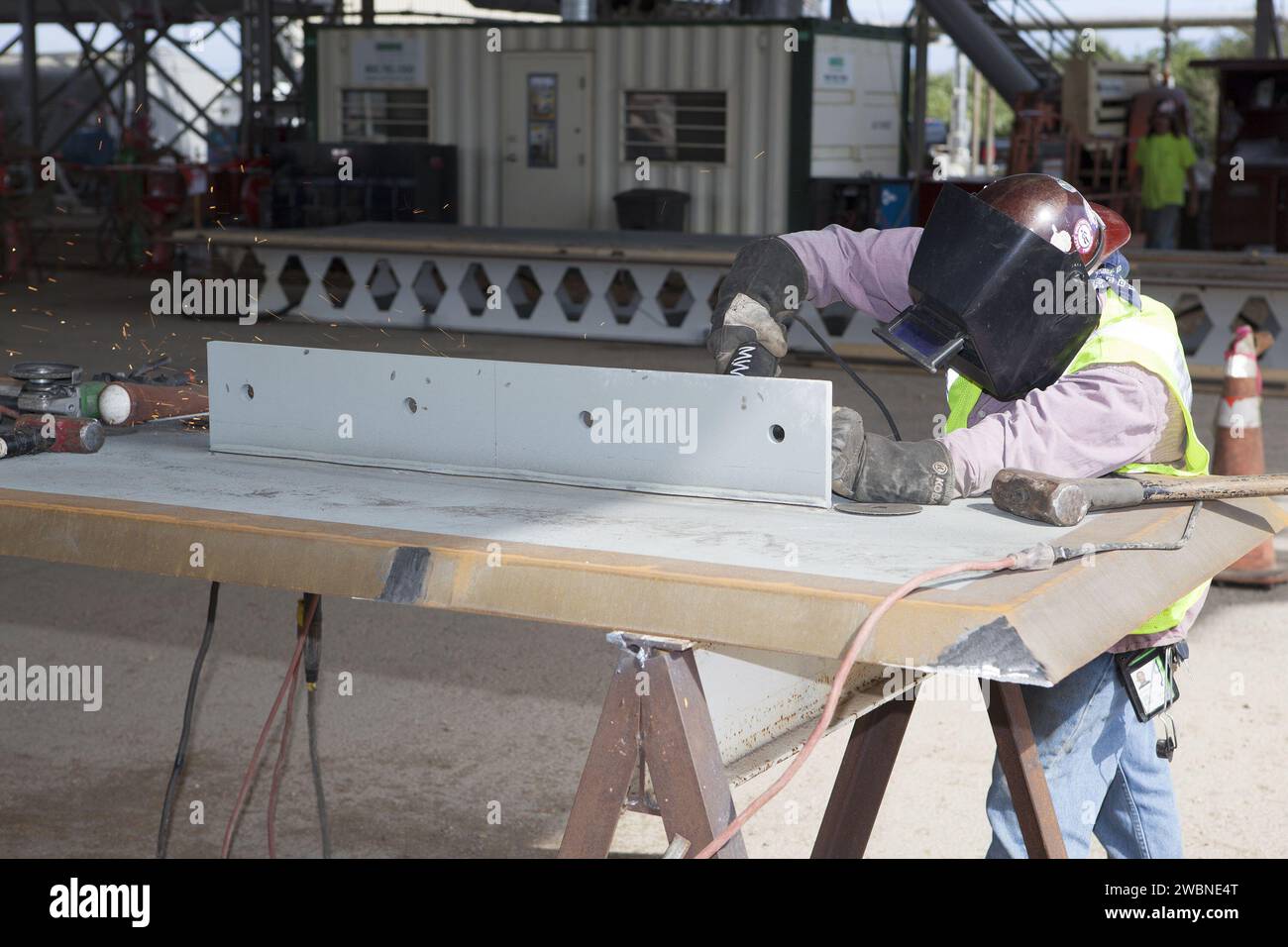 A construction worker prepares a metal component for installation on ...