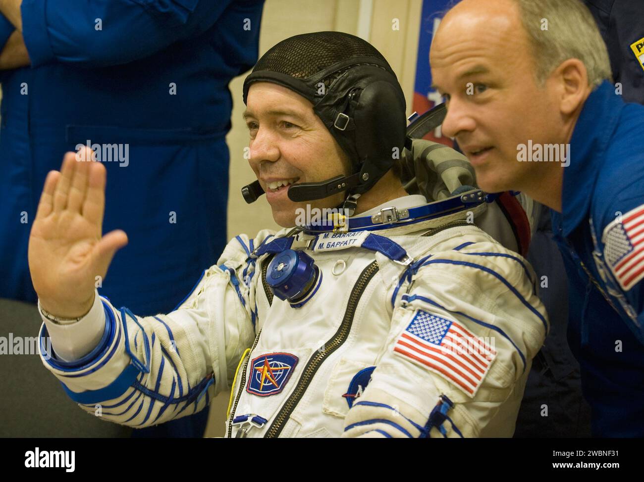 Expedition 19 Flight Engineer Michael R. Barratt, left, waves hello to ...